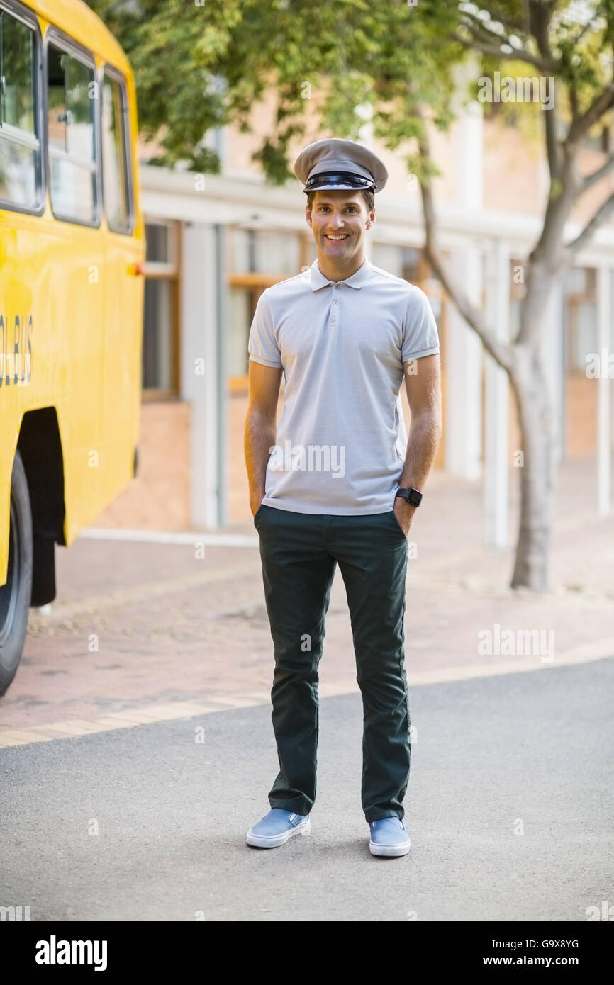 Smiling bus driver standing with hands in pocket in front of bus Stock ...