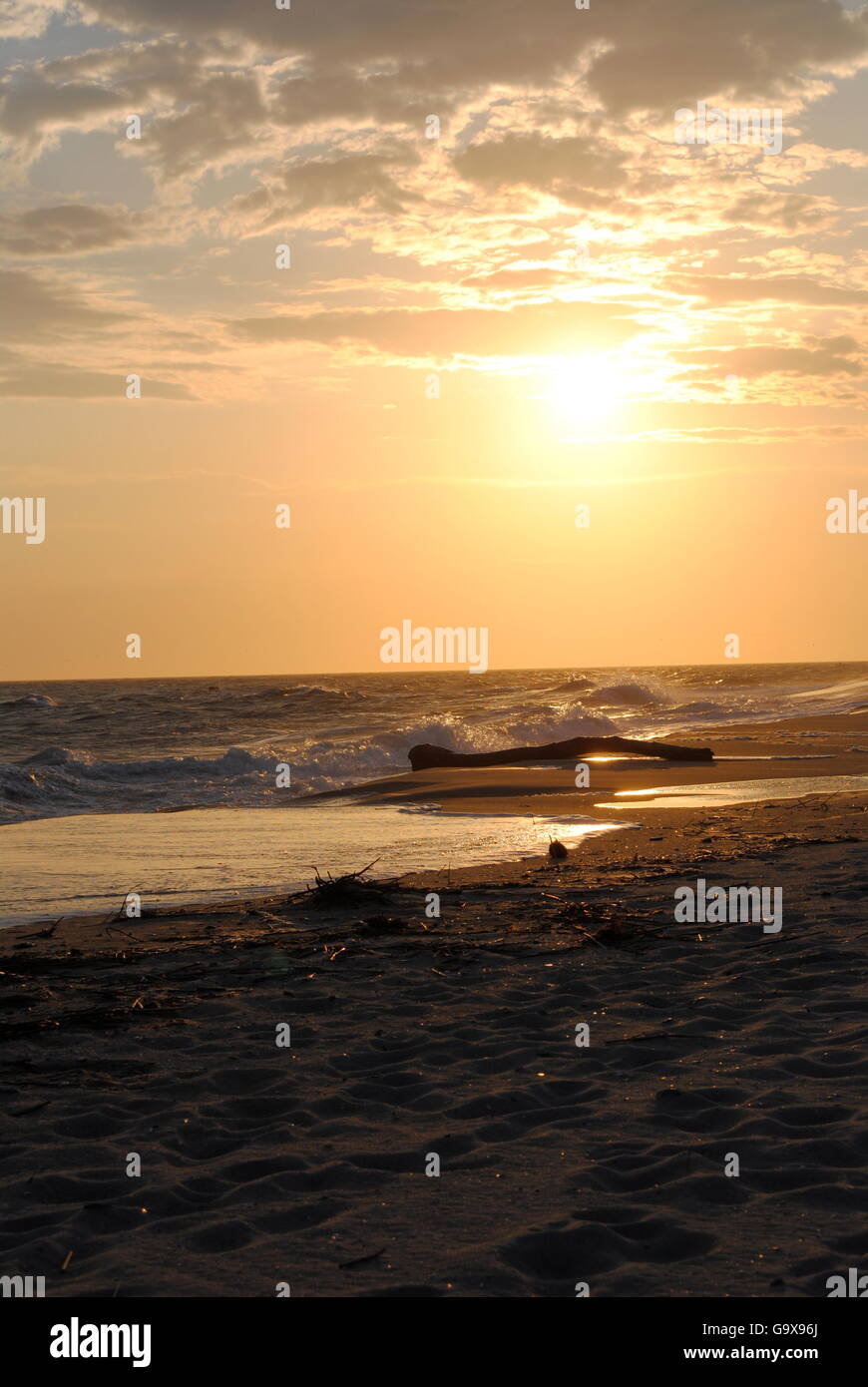 golden sunset over ocean waves in cloudy sky Stock Photo - Alamy