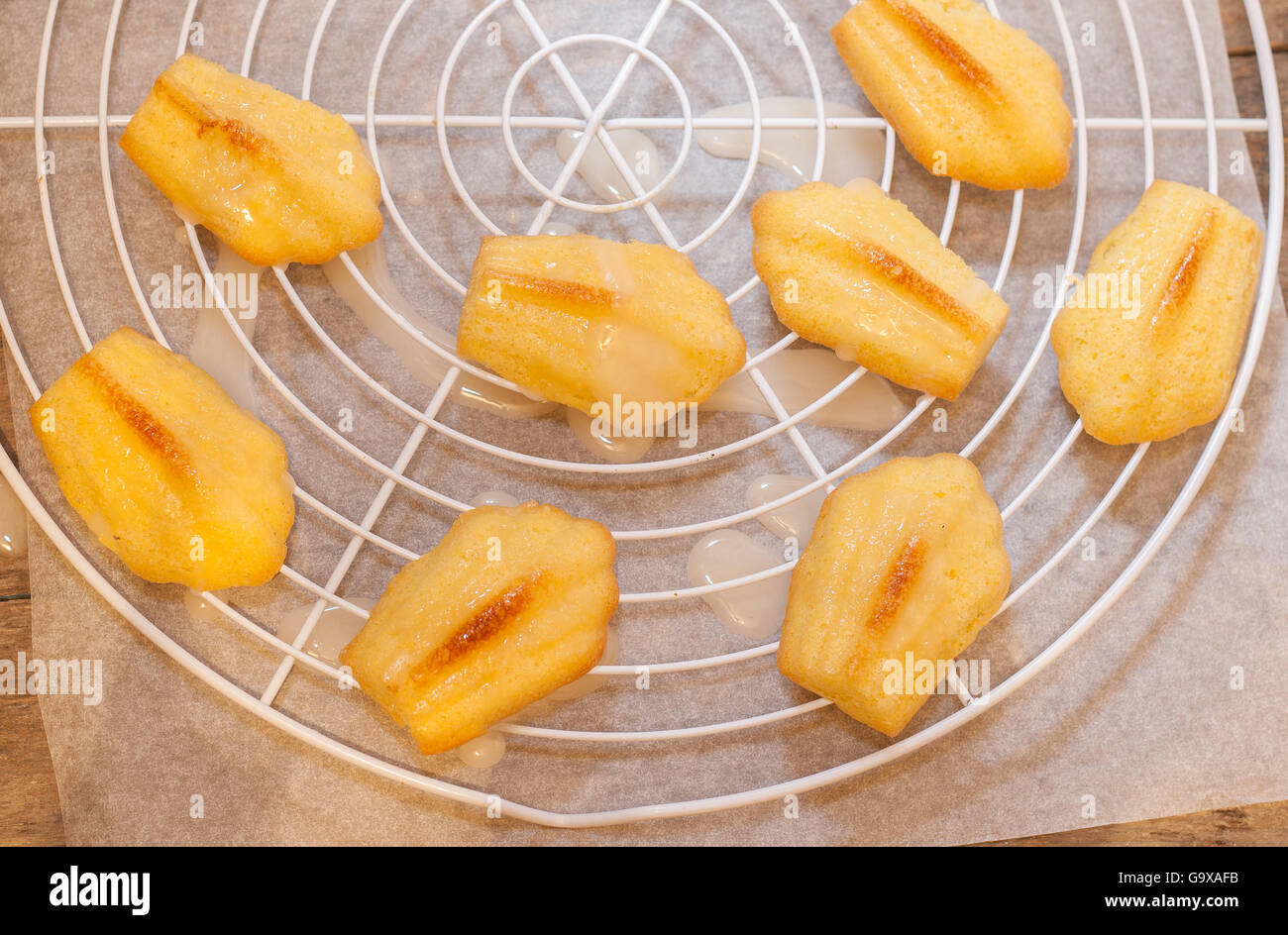 Cakes Madeleine poured icing on the grid Stock Photo - Alamy