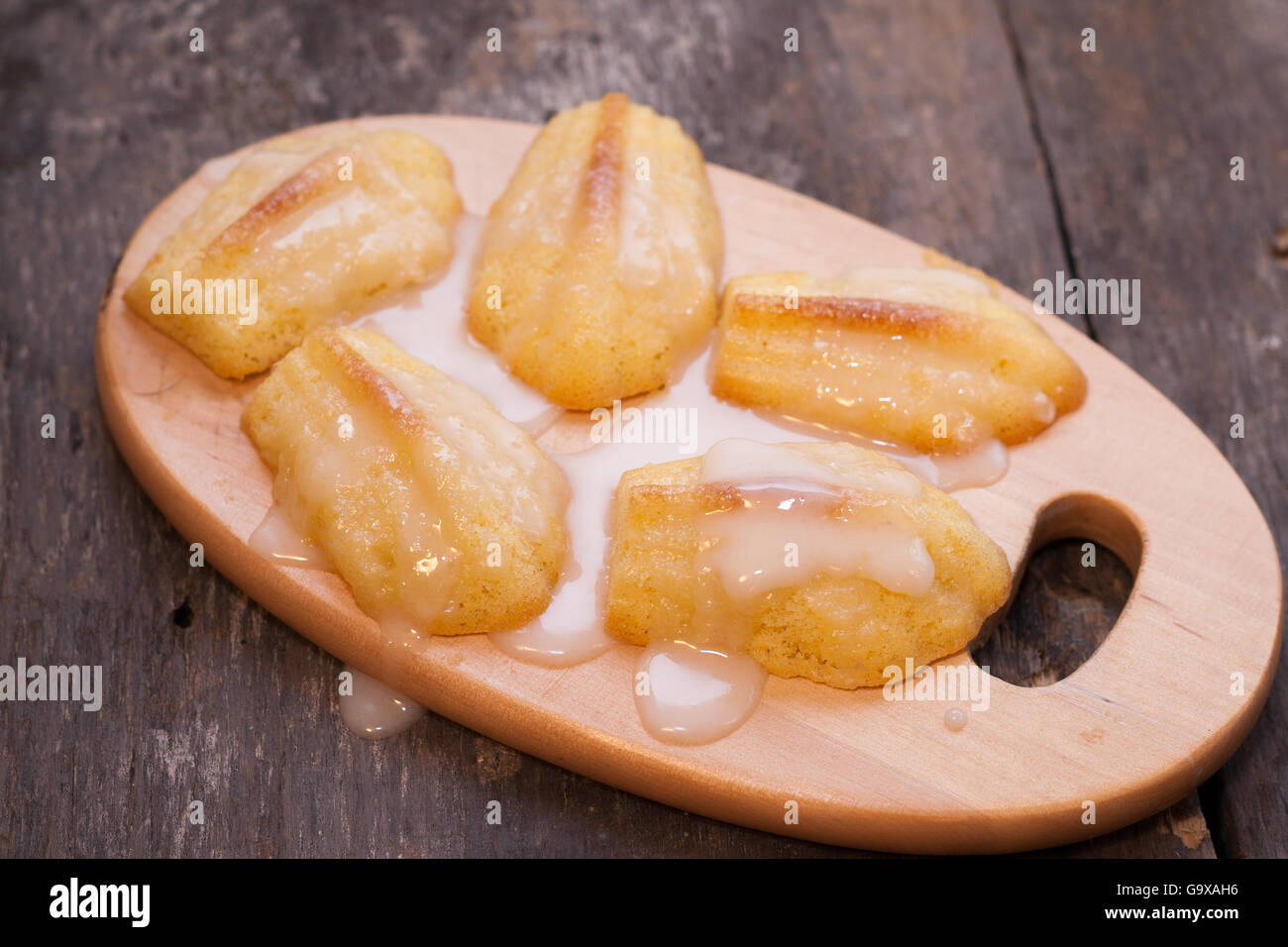 Cakes Madeleine poured icing on the grid Stock Photo - Alamy