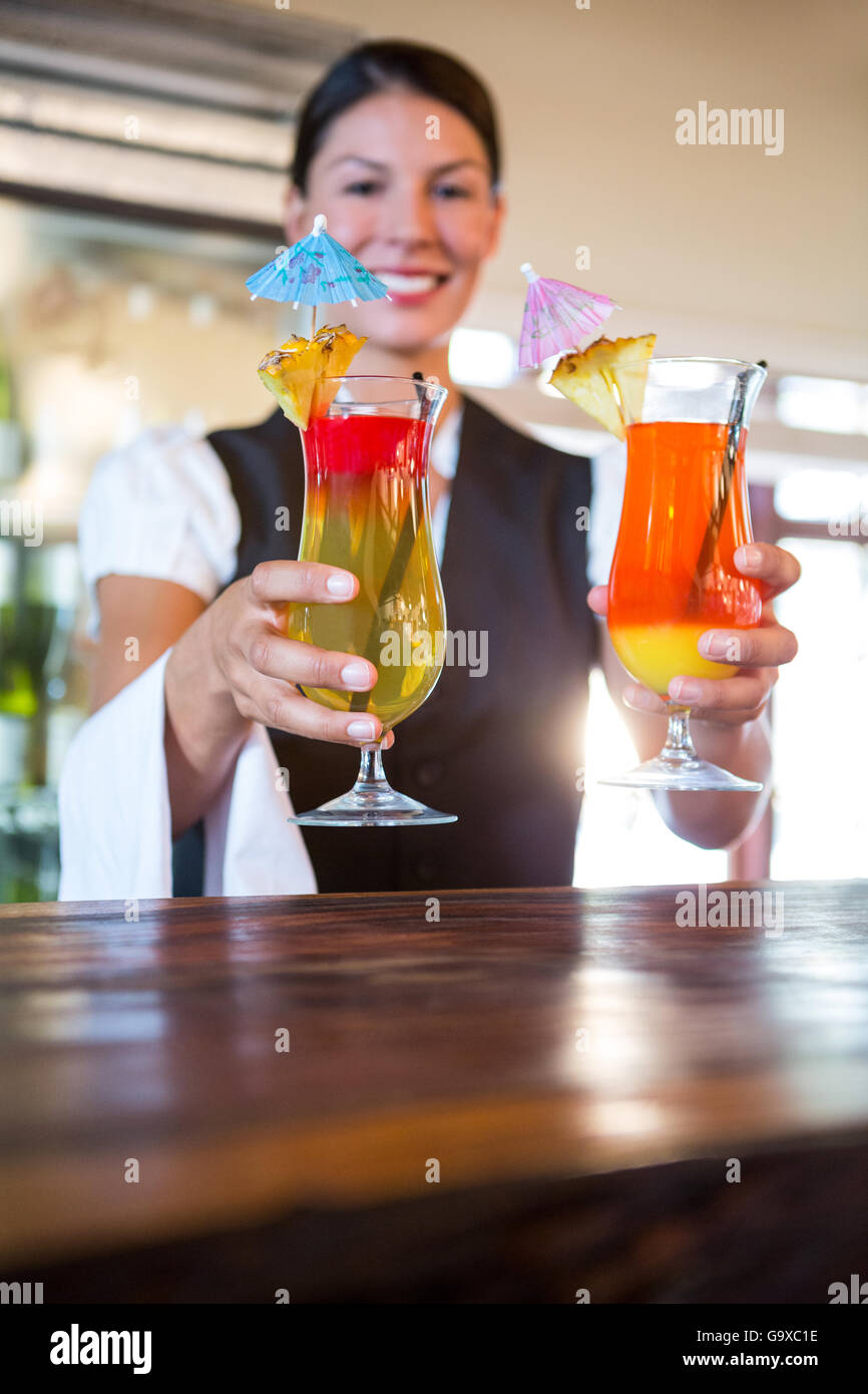 Waitress handing over cocktails Stock Photo - Alamy
