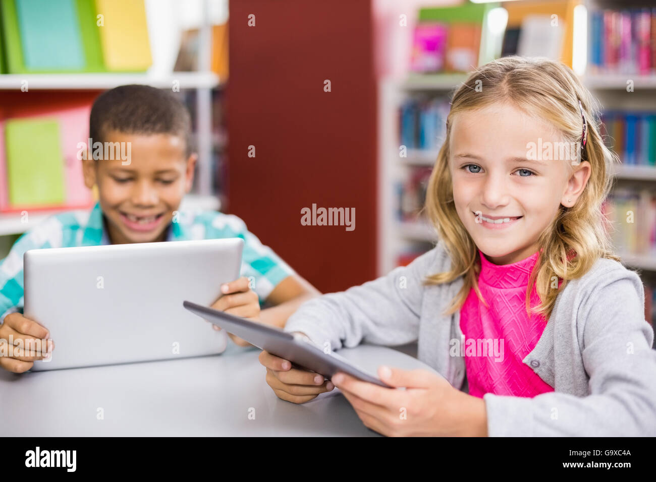 Kids using digital tablet in library Stock Photo - Alamy