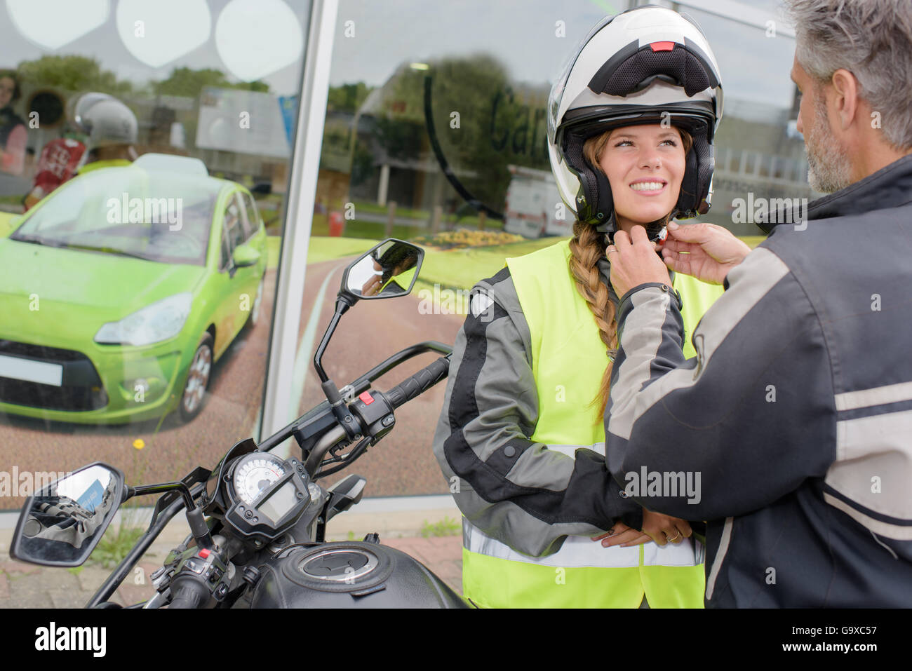 man putting helmet on his student Stock Photo - Alamy