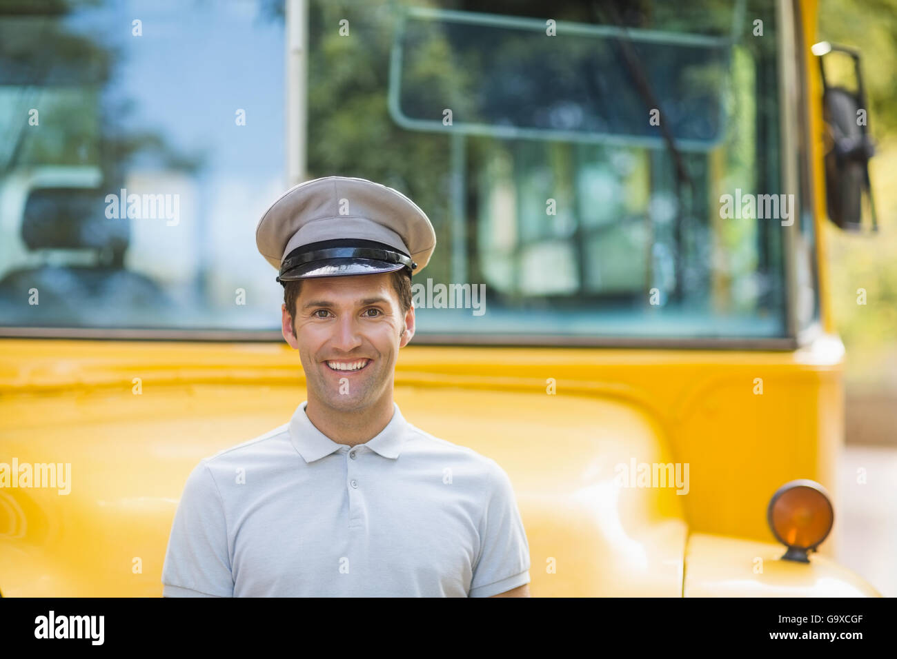 Bus driver smiling in front of bus Stock Photo - Alamy