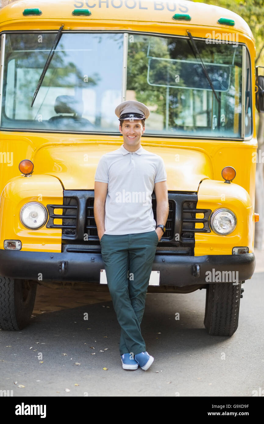Smiling bus driver leaning with hands in pocket in front of bus Stock ...