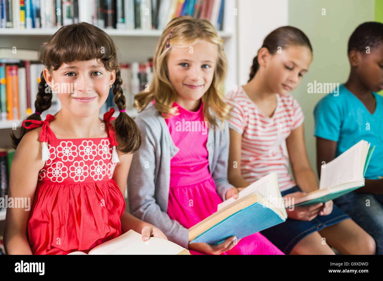 Kids reading a book in library Stock Photo - Alamy