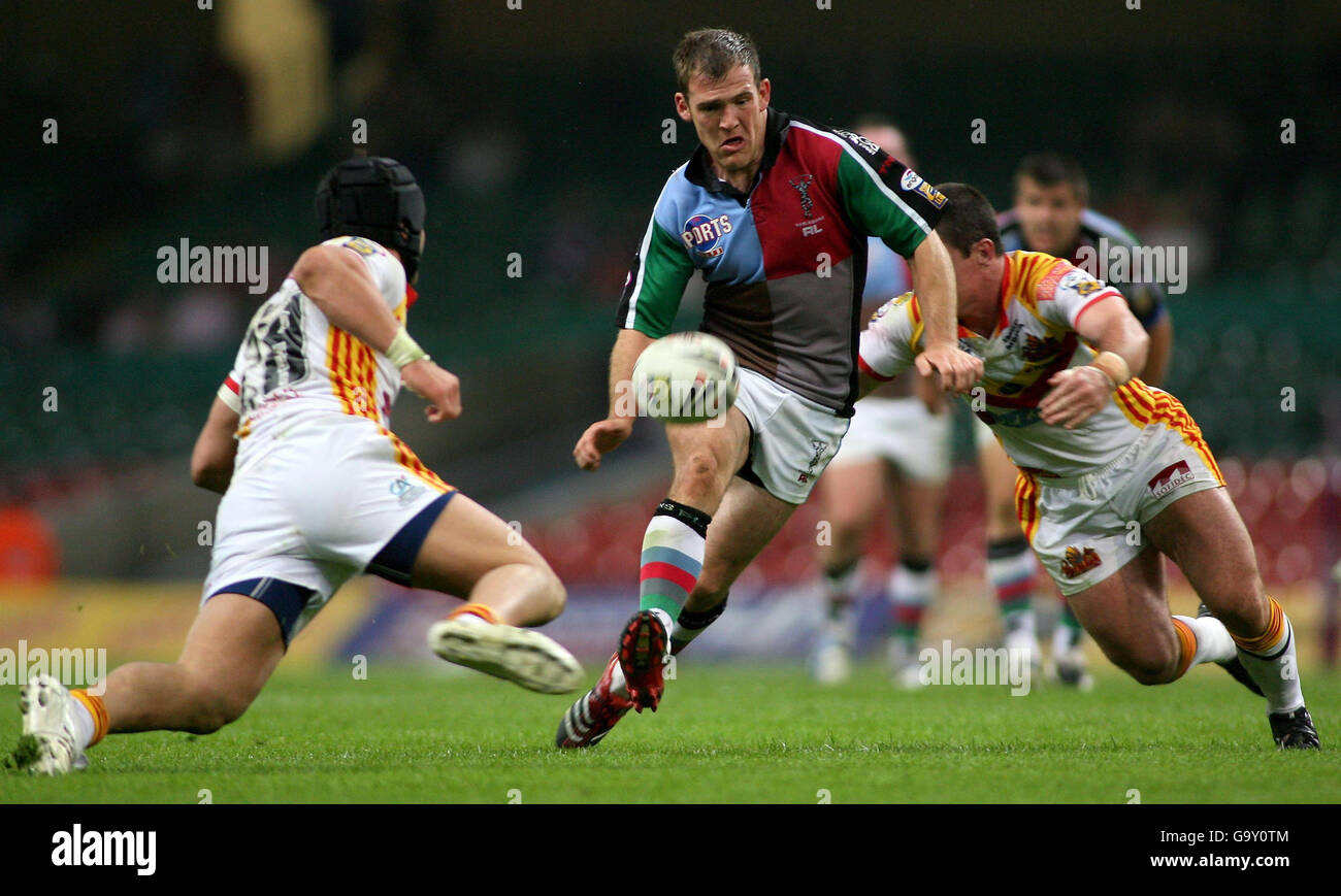 Harlequins' Danny Orr kicks past the tackles of Catalans' Andrew ...