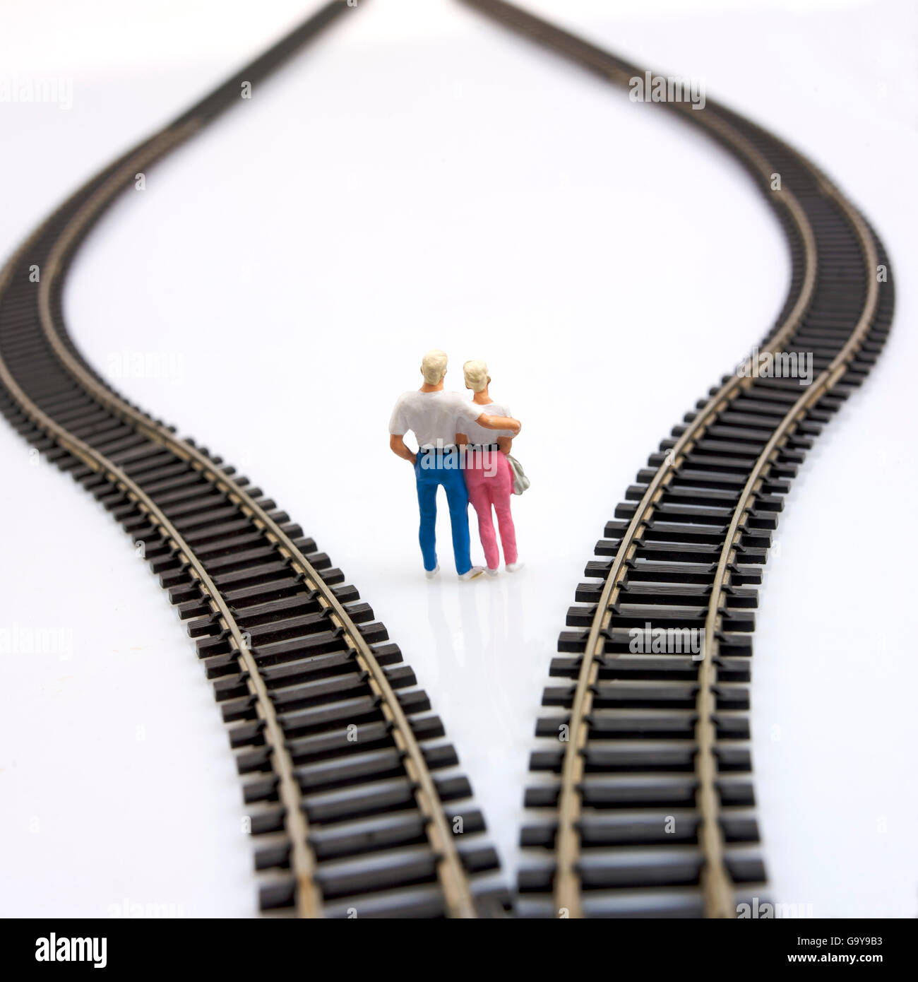 Couple, two figurines between two tracks leading into different ...