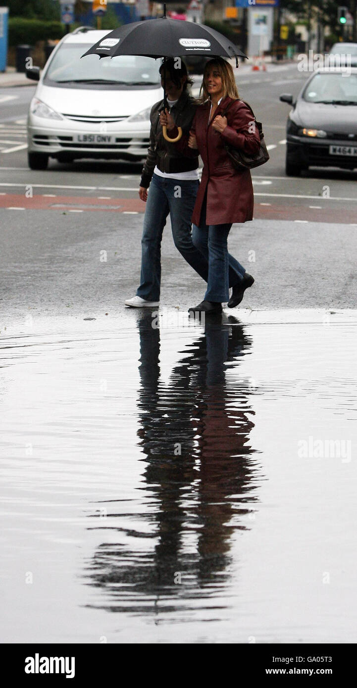 People walk past large puddle heavy rain in london hi-res stock ...