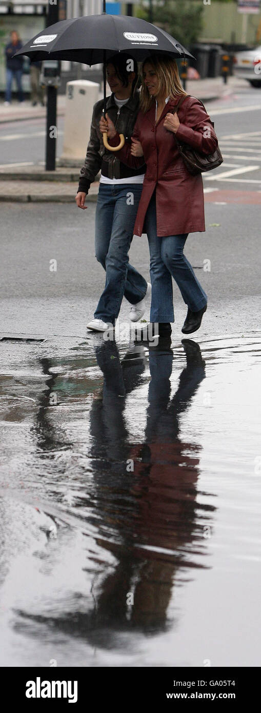People walk past large puddle heavy rain in london hi-res stock ...