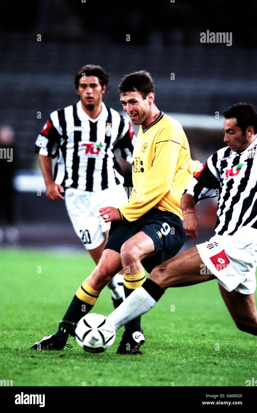 (L-R) Celtic's Chris Sutton plays the ball past the outstretched leg of ...