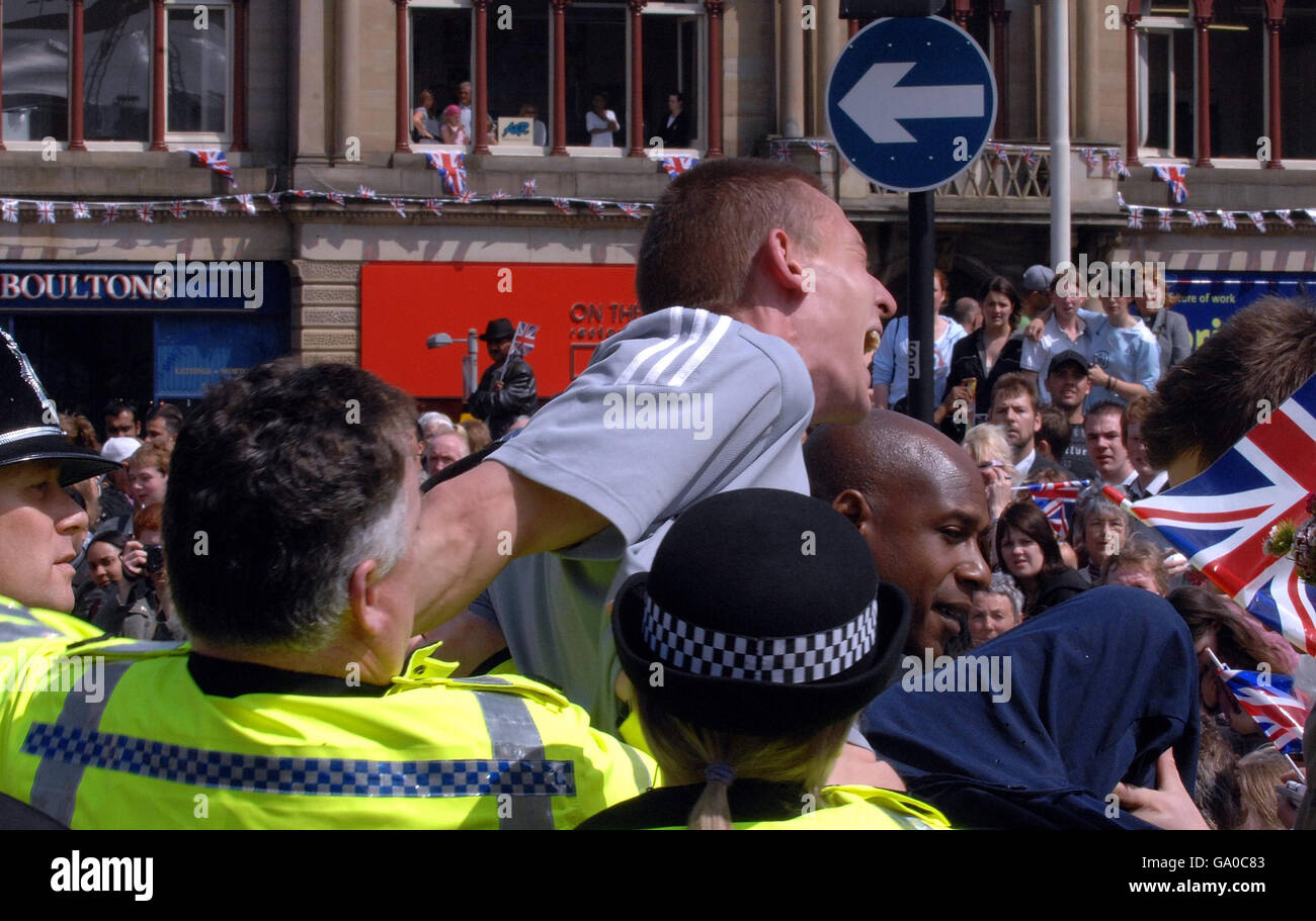 A man is led away from the crowd by police during the visit to St ...