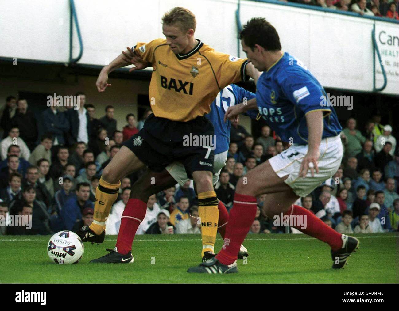 Preston's Lee Cartwright is under pressure from Portsmouth's Justin ...