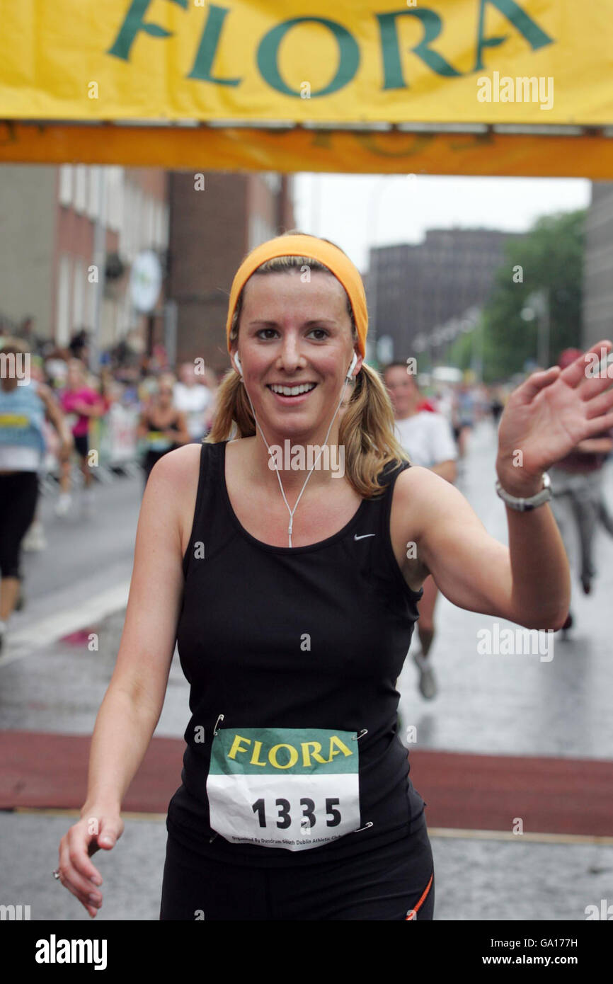 TV3's Laura Ryan waves to some friends as she crosses the finish line ...
