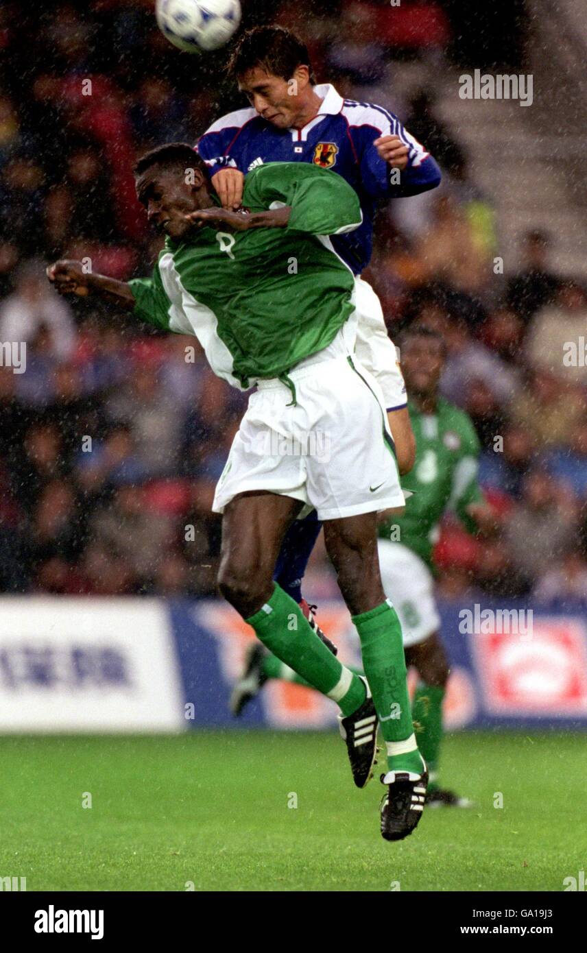 Tsuneyasu miyamoto heads clear from nigerias victor agali hi-res stock ...