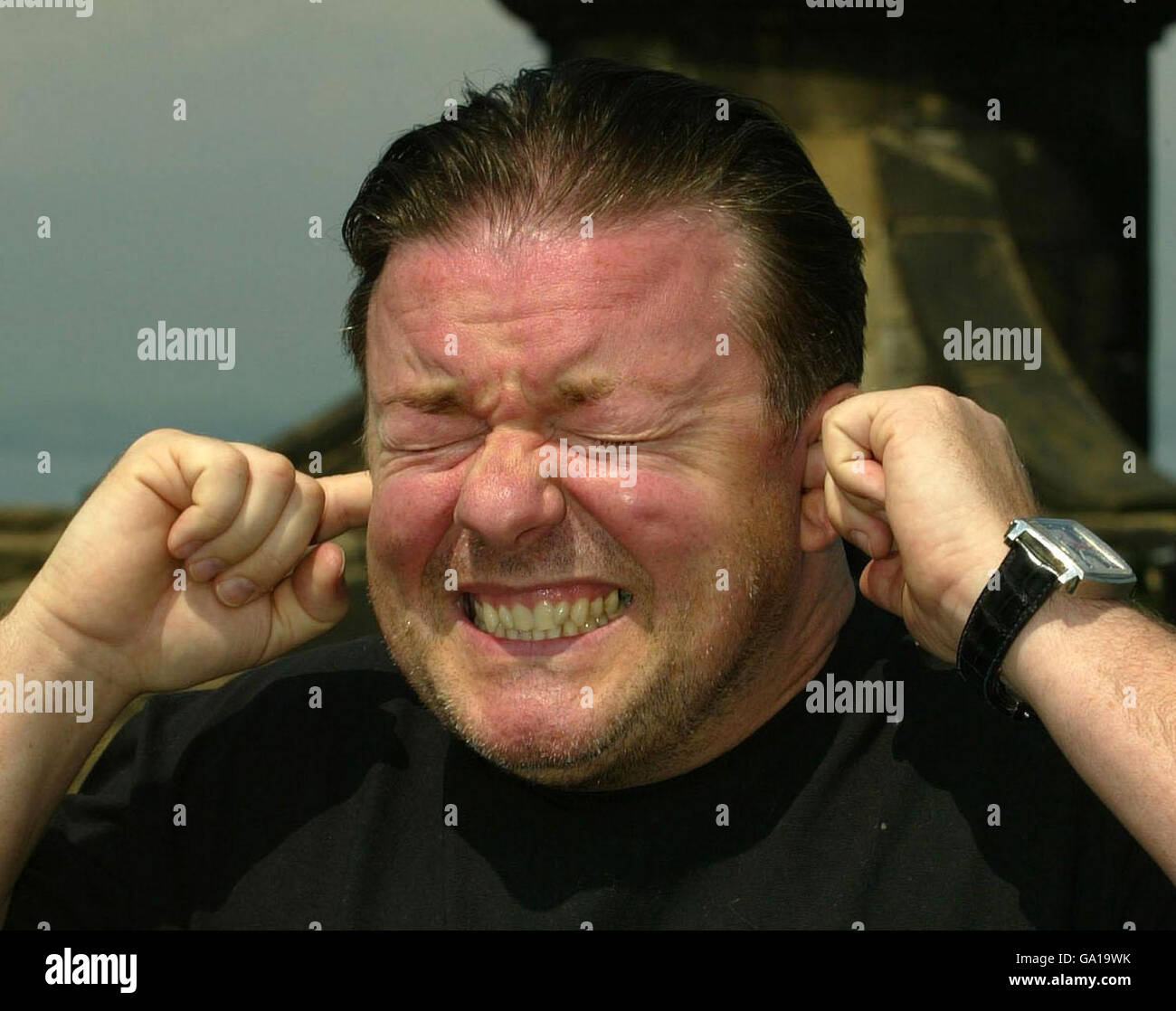 Comedian Ricky Gervais covers his ears as the 1 o'clock Edinburgh ...