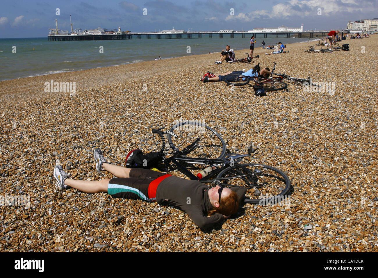 An exhausted competitor relaxes on the beach after arriving in Brighton ...