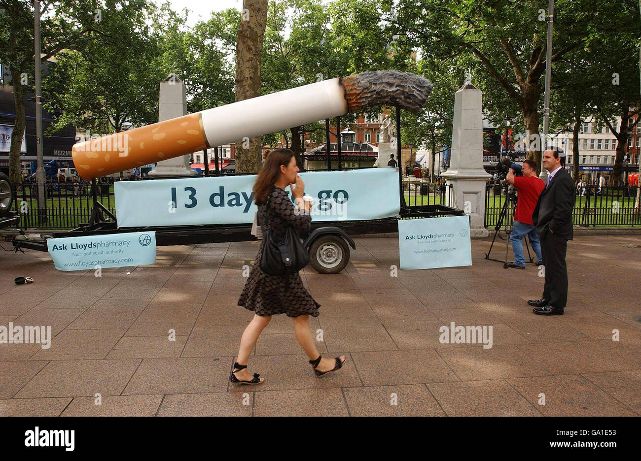 An unidentified woman smokes a cigarette as she walks past a 25 foot ...