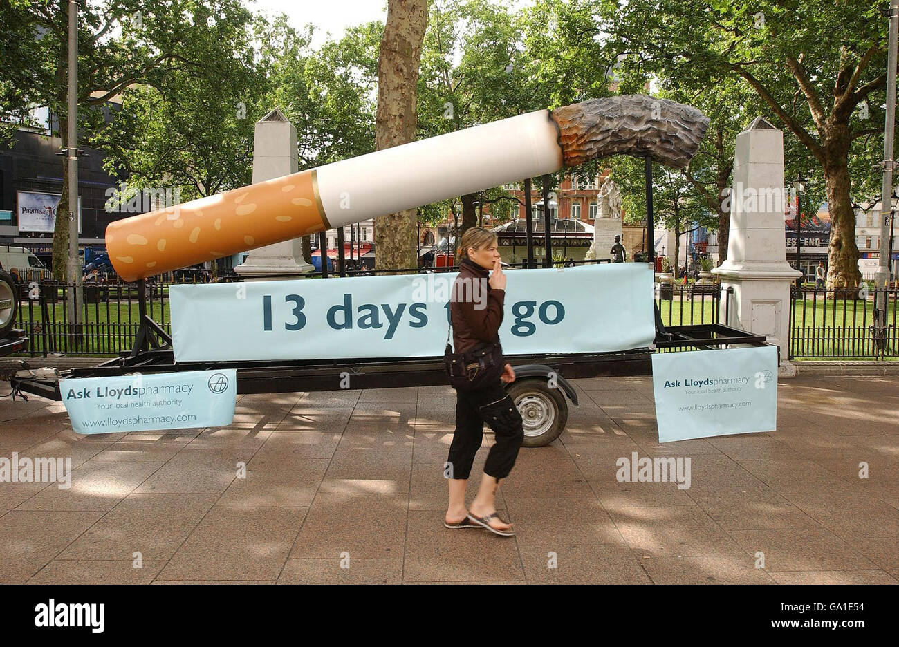 An unidentified woman smokes a cigarette as she walks past a 25 foot ...