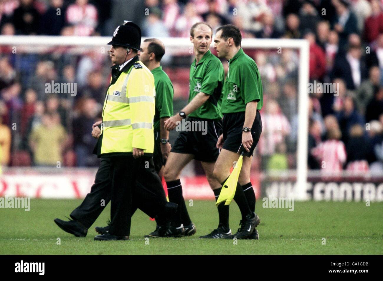 Referee Mike Riley is given a police escort off the pitch after the ...