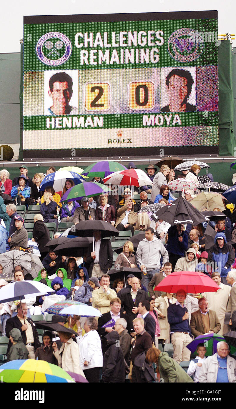 Spectators shield from the rain as giant screen displays players ...