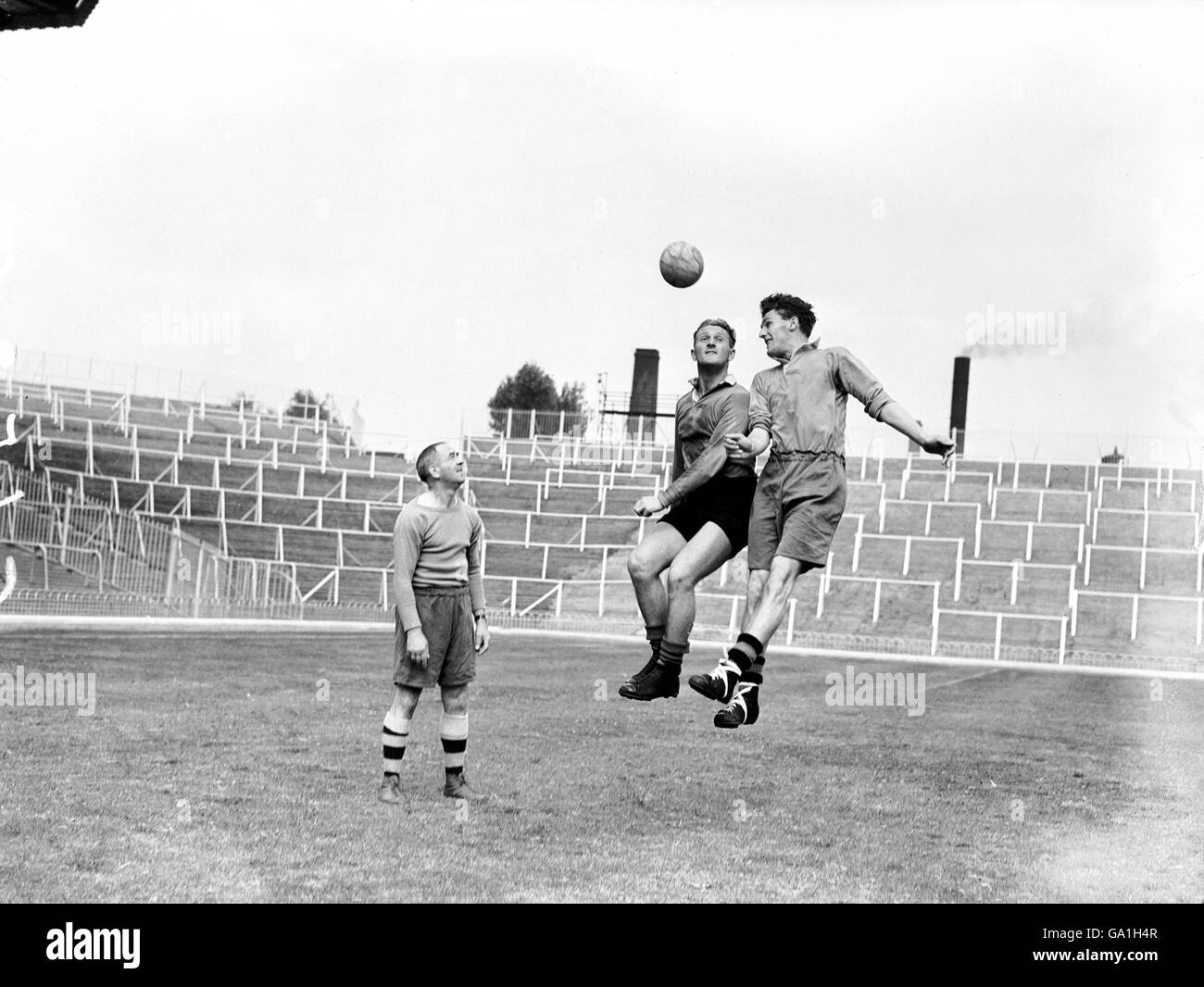 (L-R) Arsenal coach Alex James examines the heading technique of John ...