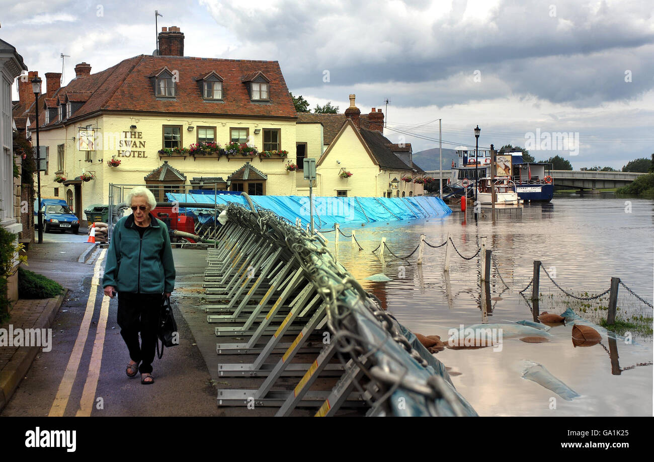 An Upton on Severn resident walks behind the flood defences today as ...