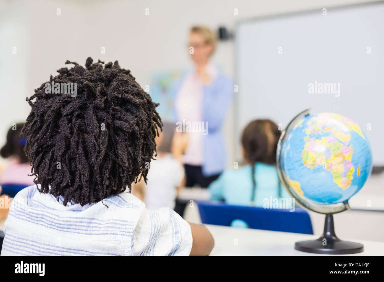 Rear view of school boy studying in classroom Stock Photo - Alamy