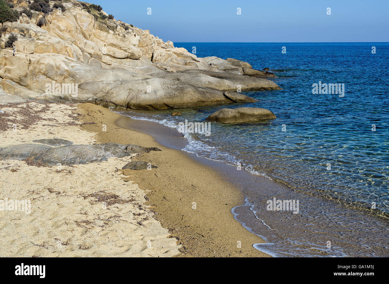 Rocks in a sandy beach in Sithonia, Chalkidiki, Greece, with crystal ...