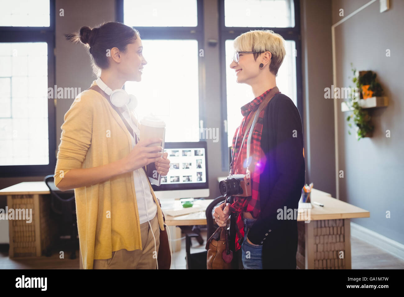 Graphic designers smiling while talking Stock Photo - Alamy