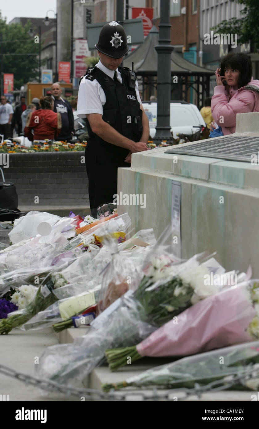 A police officer looks at floral tributes in Luton town centre ...