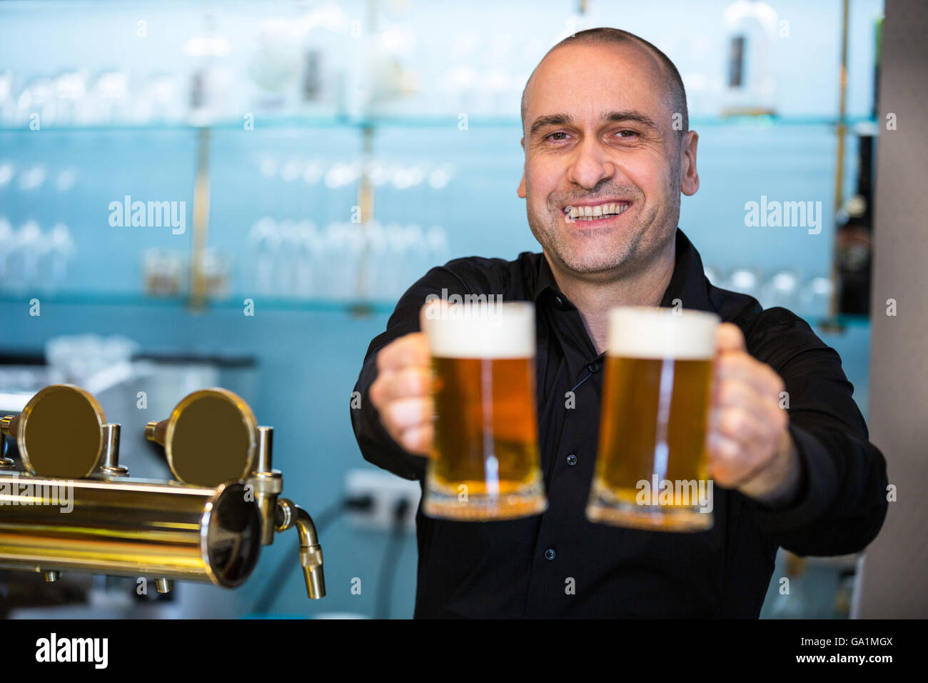 Portrait of bar tender offering beer Stock Photo - Alamy