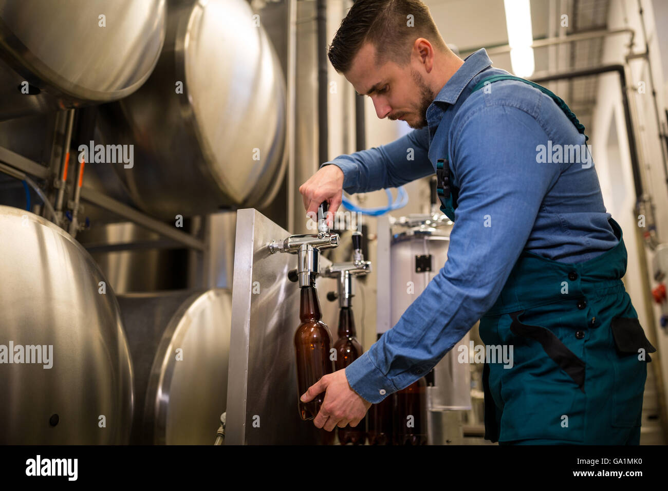 Brewer filling beer in bottle Stock Photo - Alamy