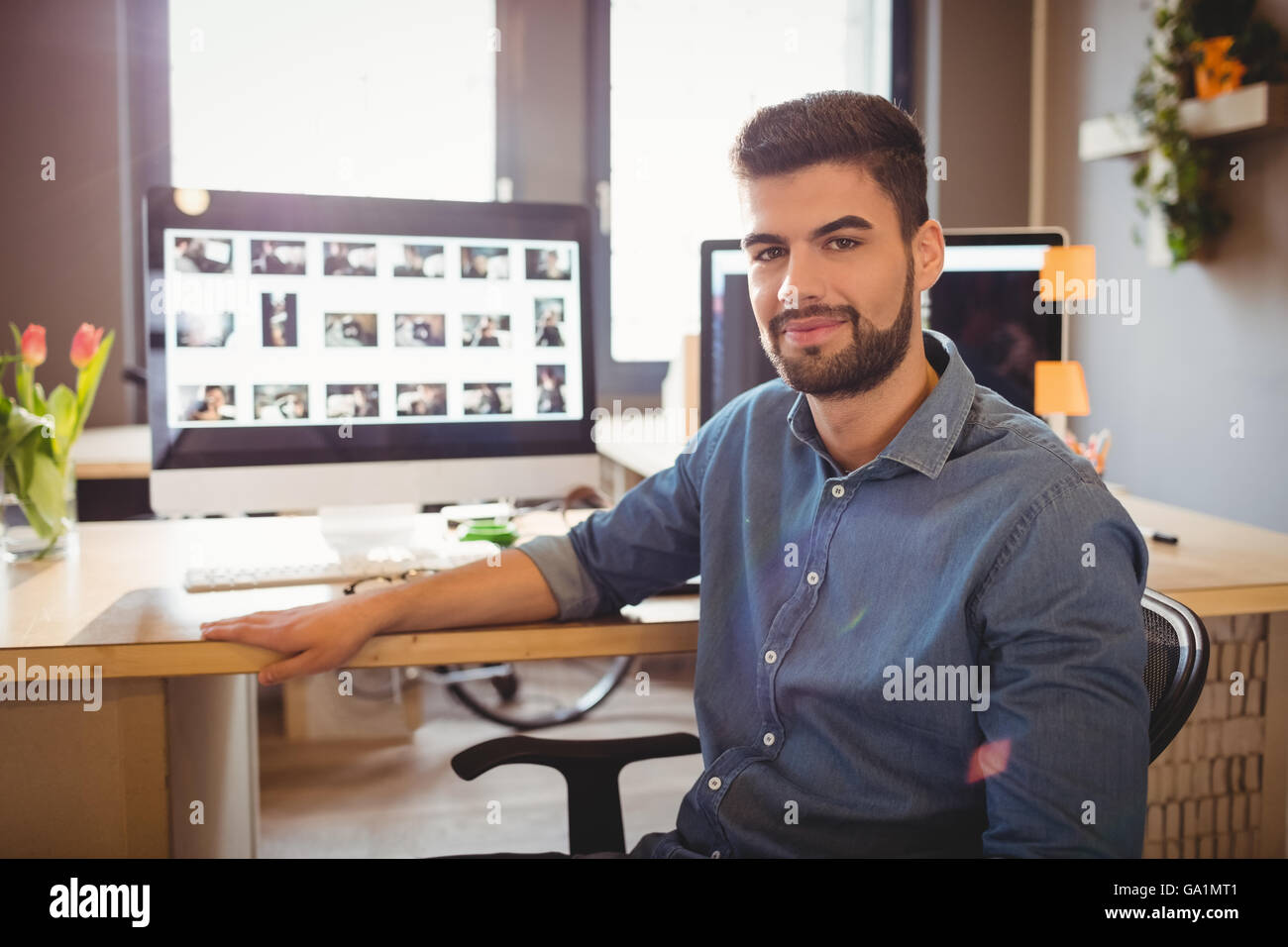 Happy graphic designer sitting at office Stock Photo - Alamy