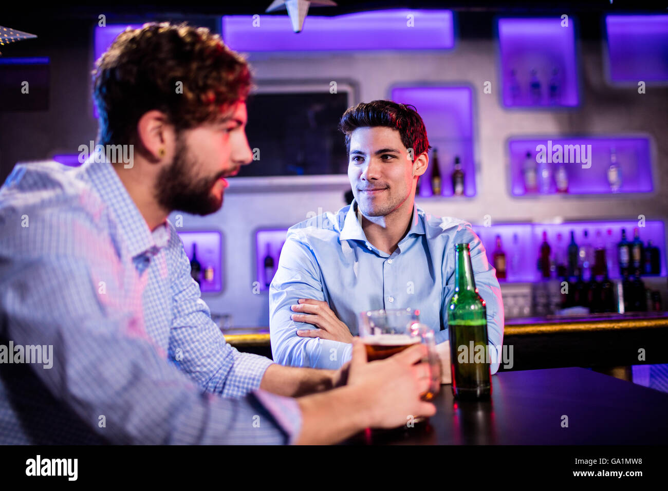 Friends sitting at bar counter and having beer Stock Photo - Alamy