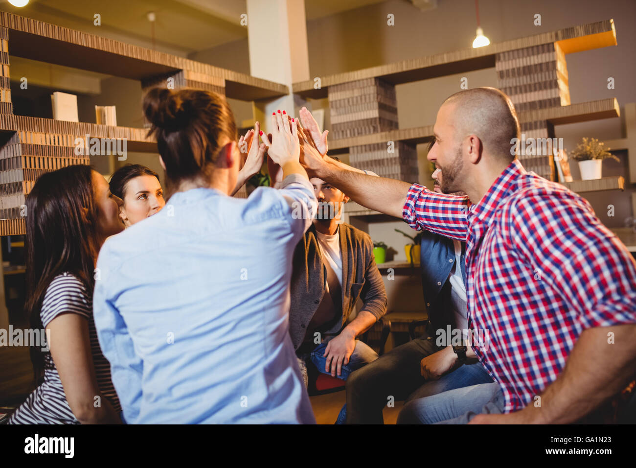 Colleagues giving high five at office Stock Photo - Alamy