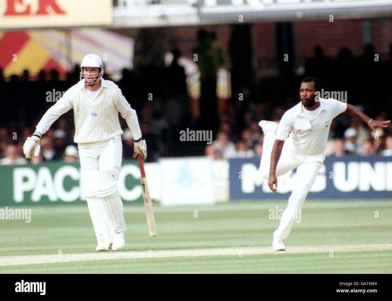 West Indies' Malcolm Marshall (r) follows through after bowling ...