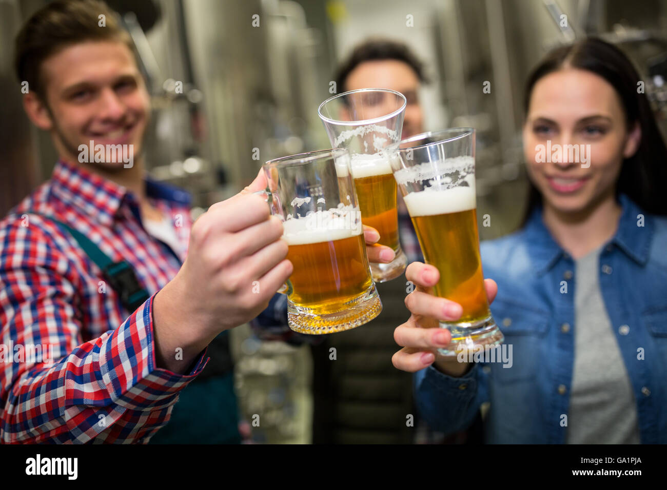 Brewers toasting beers at brewery factory Stock Photo - Alamy