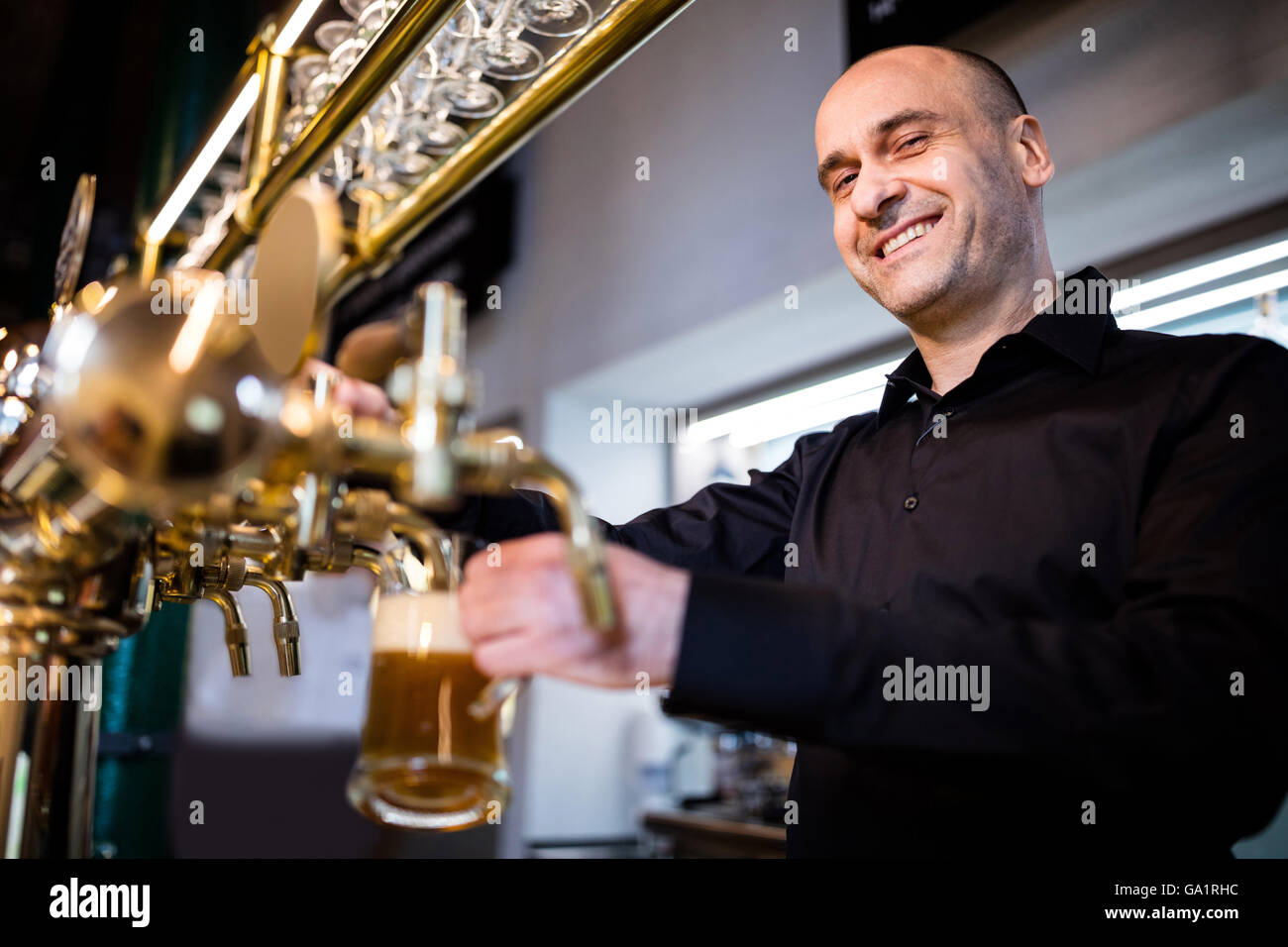 Brewer filling beer in beer glass from beer pump Stock Photo - Alamy
