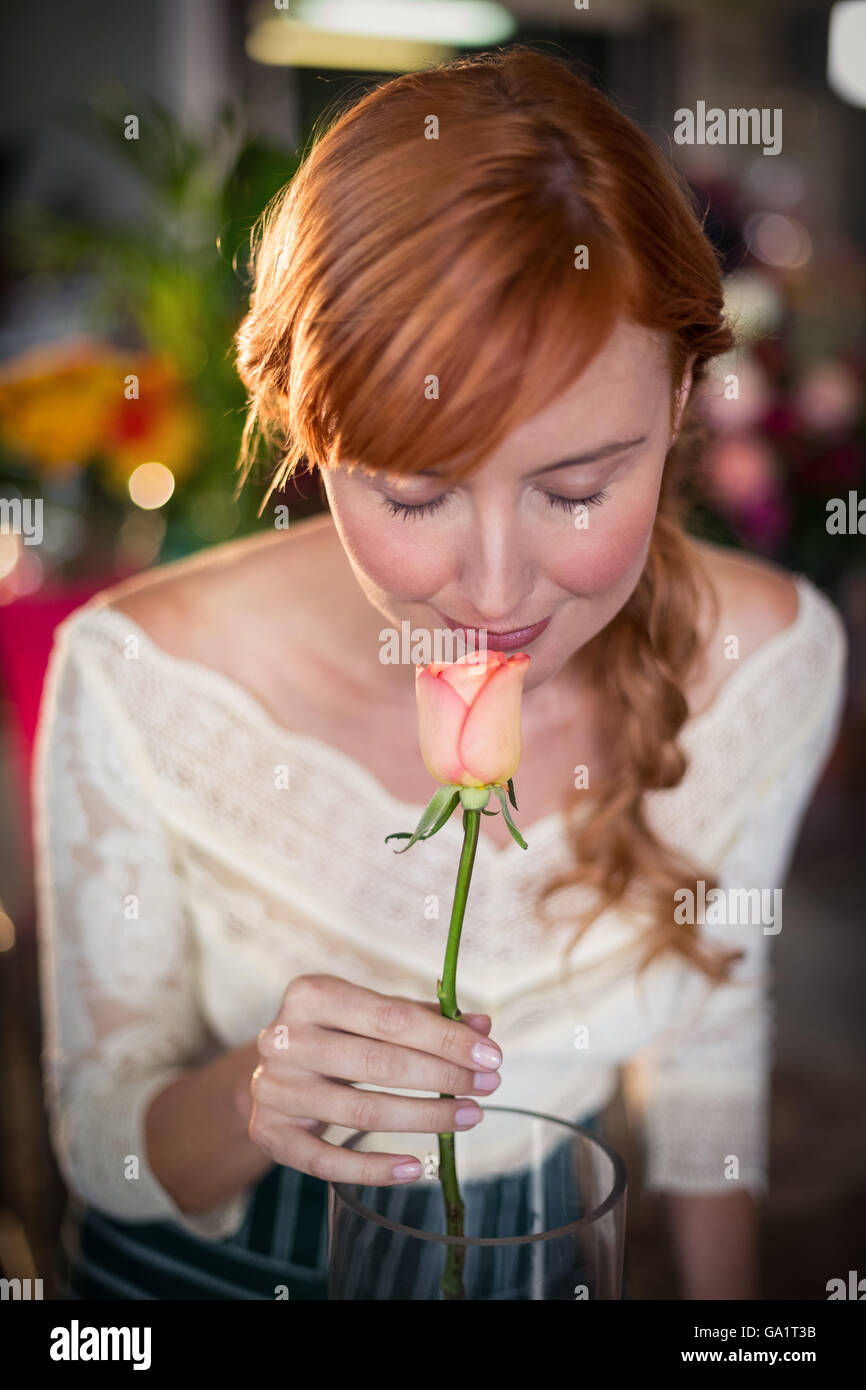 Female florist smelling a rose flower Stock Photo - Alamy