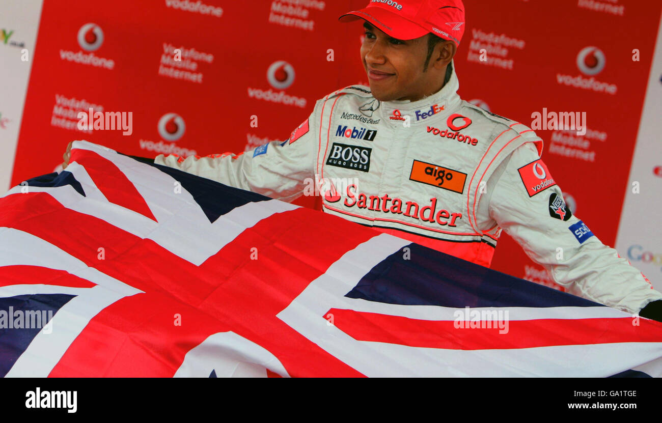 Formula One Driver Lewis Hamilton, holds a union Jack flag aloft during ...