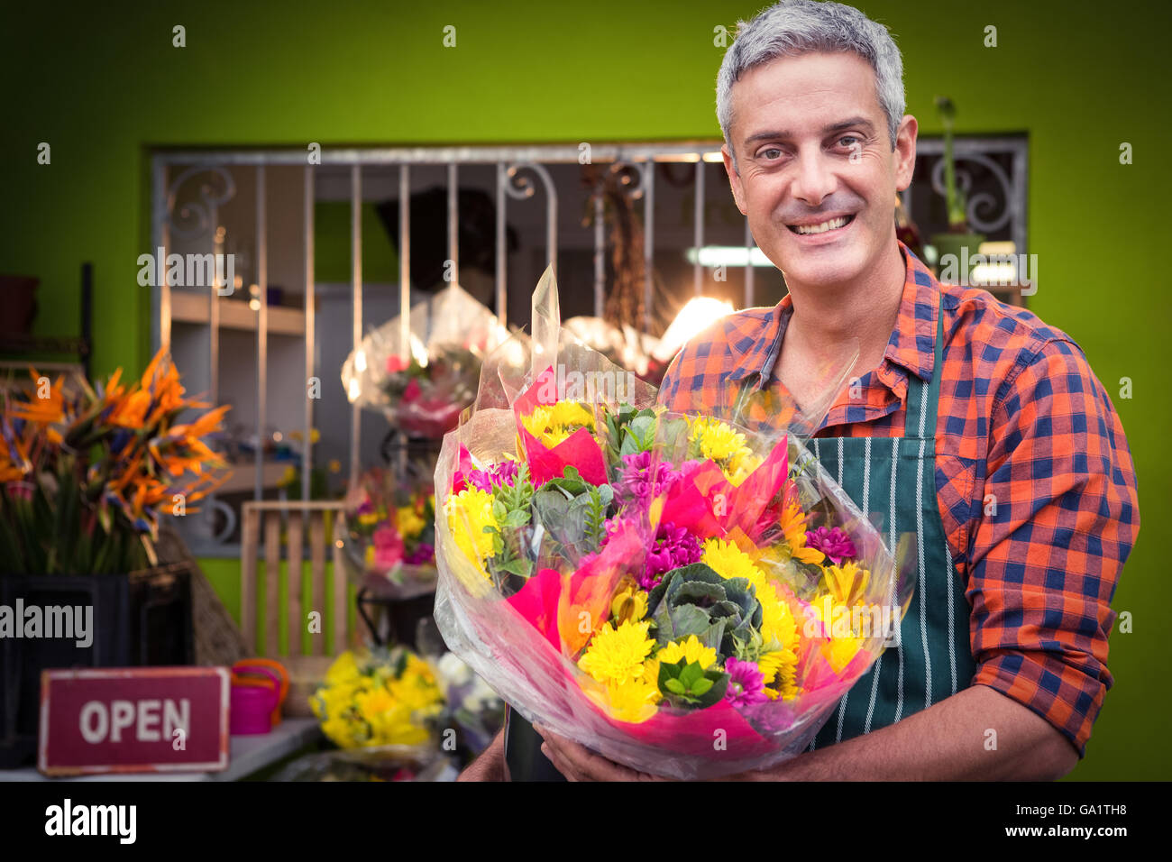 Male florist holding flower bouquet at flower shop Stock Photo - Alamy