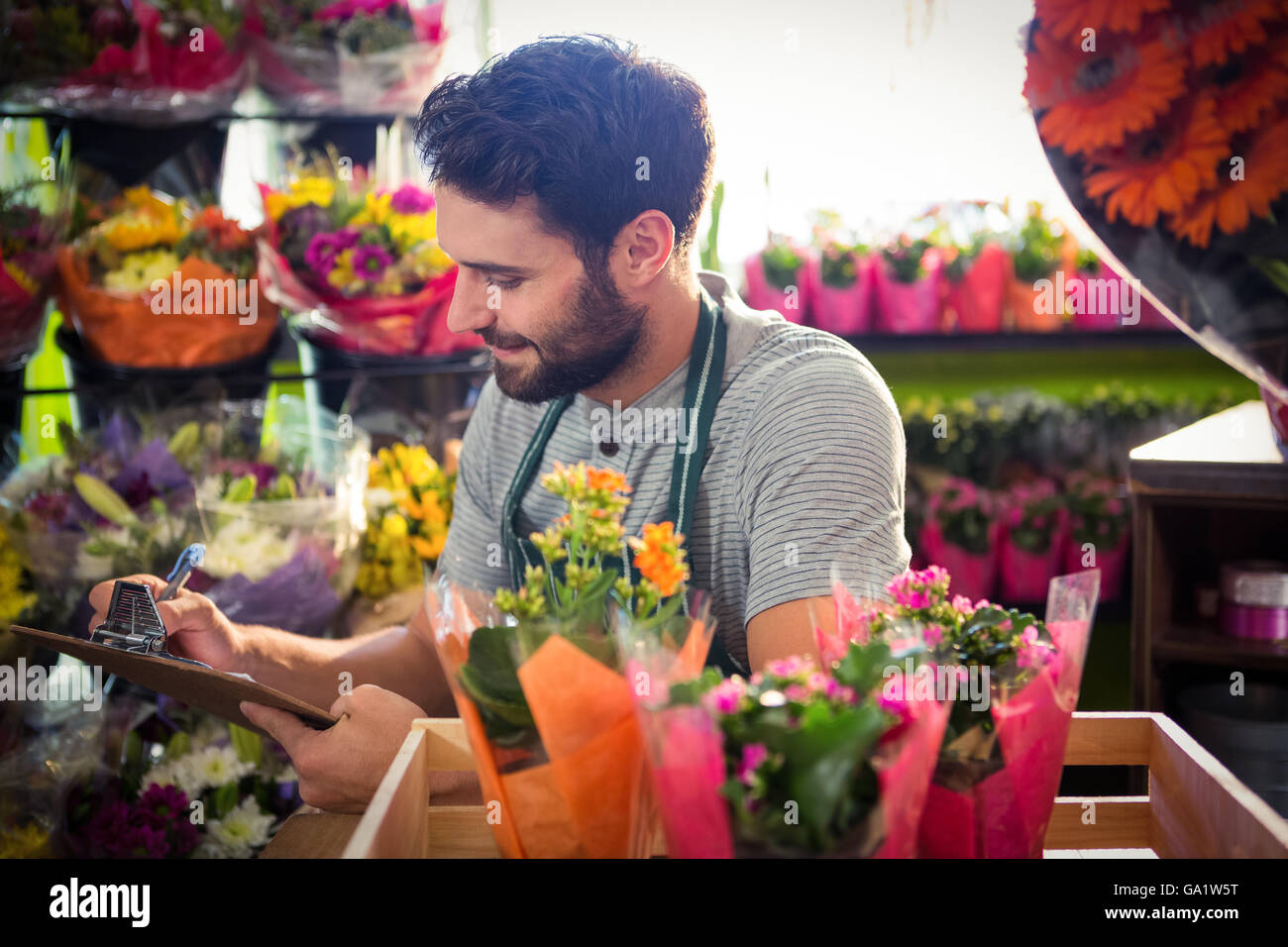 Male florist writing and making notes Stock Photo - Alamy