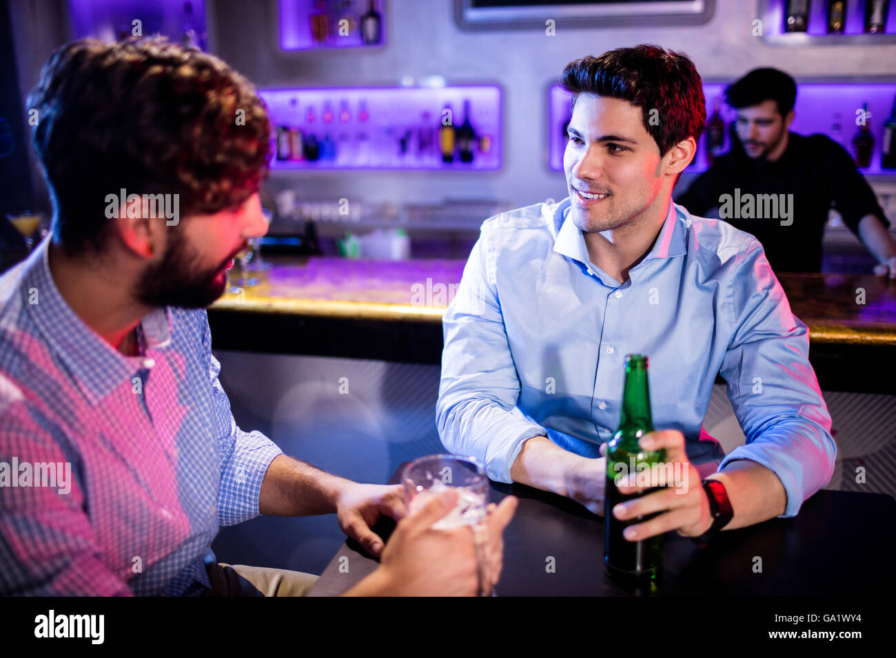 Smiling friends interacting having beer hi-res stock photography and ...