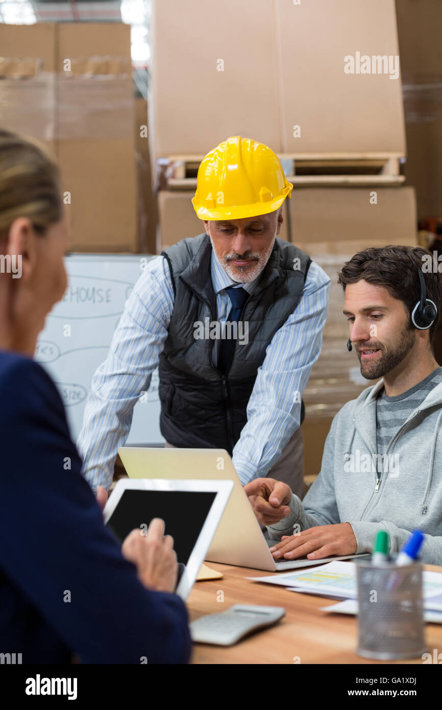 Workers using digital devices in warehouse Stock Photo - Alamy