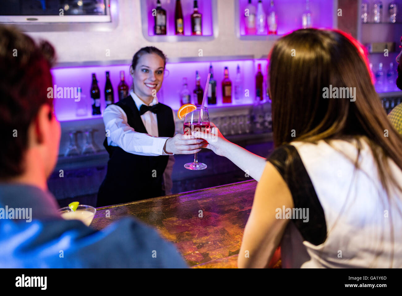Barmaid serving drink to woman Stock Photo - Alamy