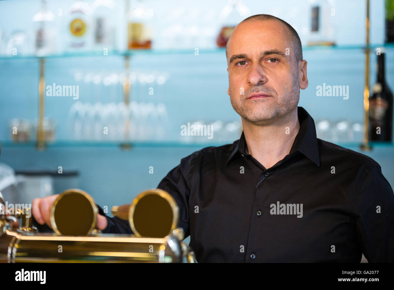Bar tender standing at bar counter Stock Photo - Alamy