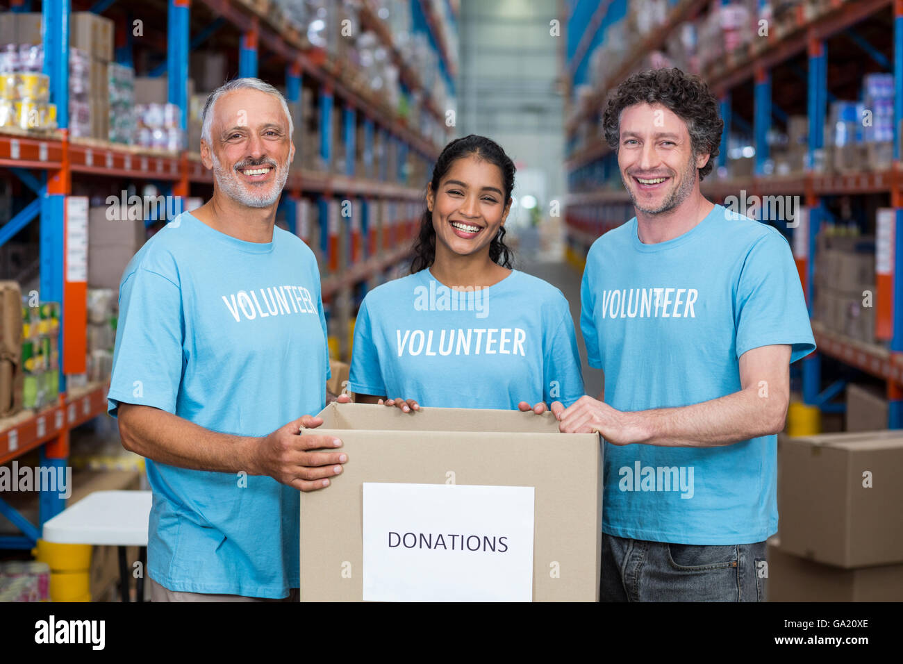Happy volunteers are smiling and posing with a donations box Stock ...