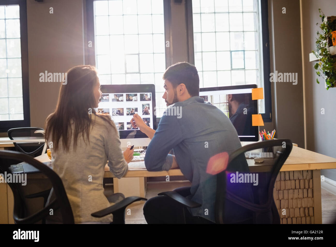 Graphic designers working at desk in the office Stock Photo - Alamy