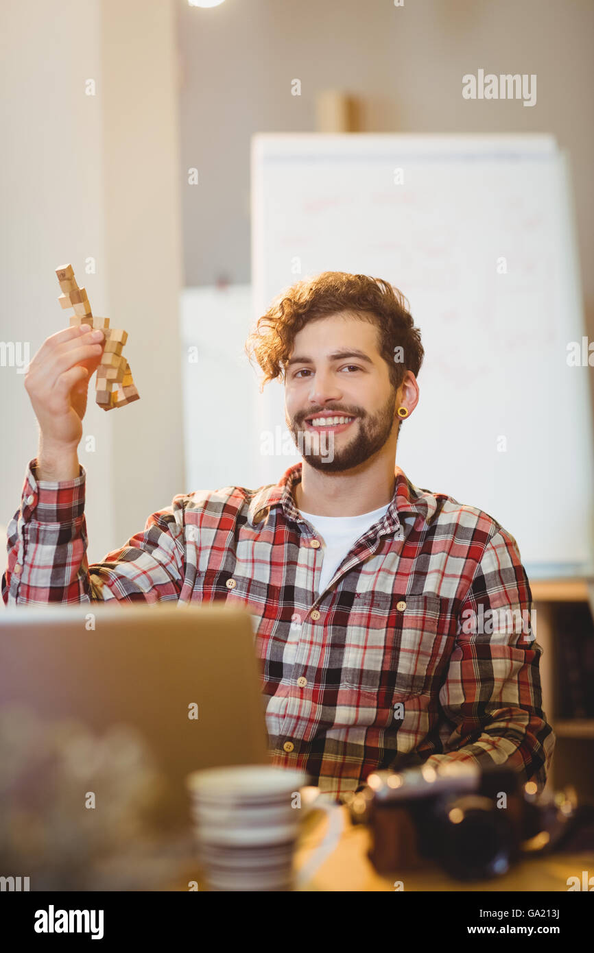 Happy graphic designer holding a wooden block Stock Photo - Alamy